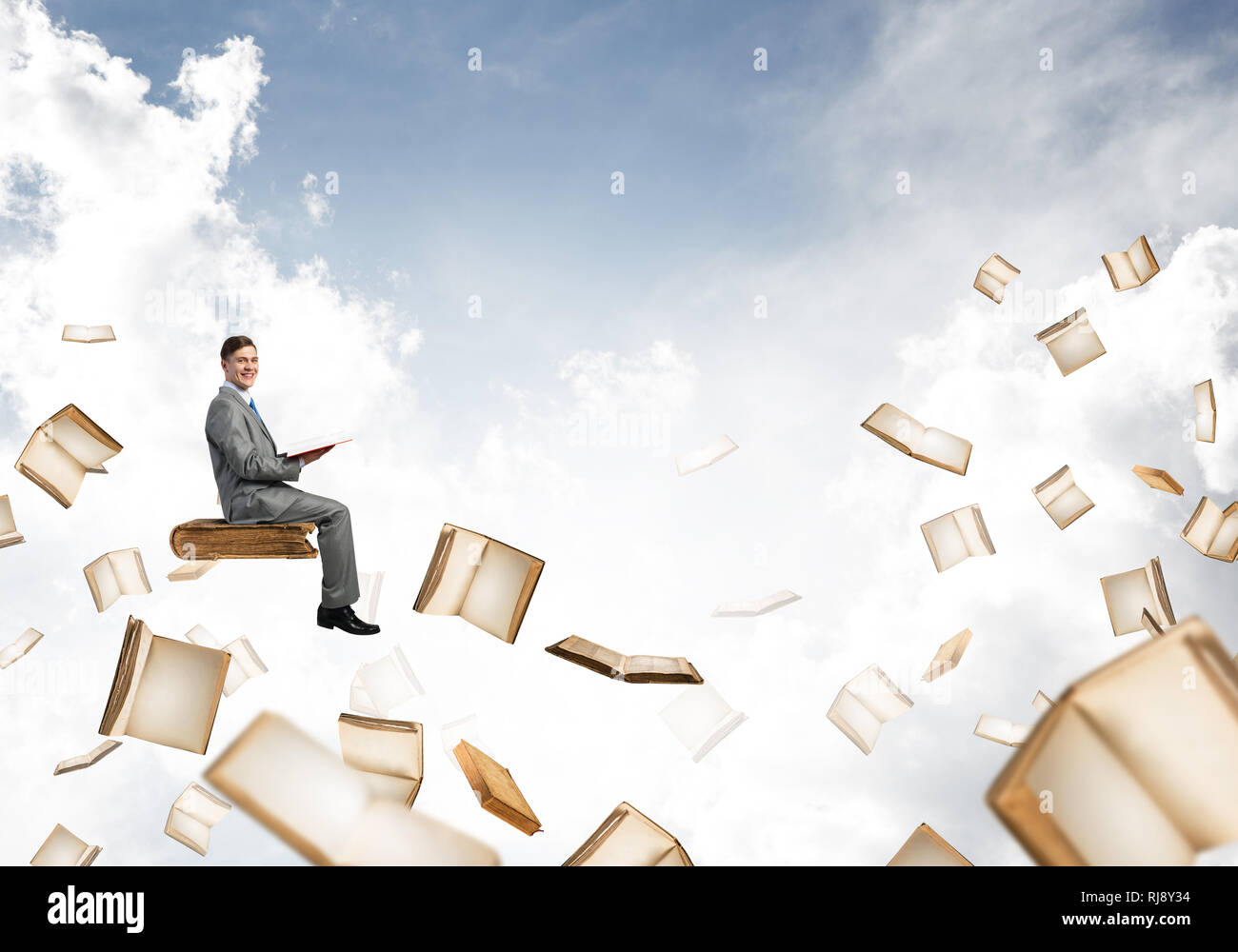 Man reading book and many of them flying in air Stock Photo - Alamy