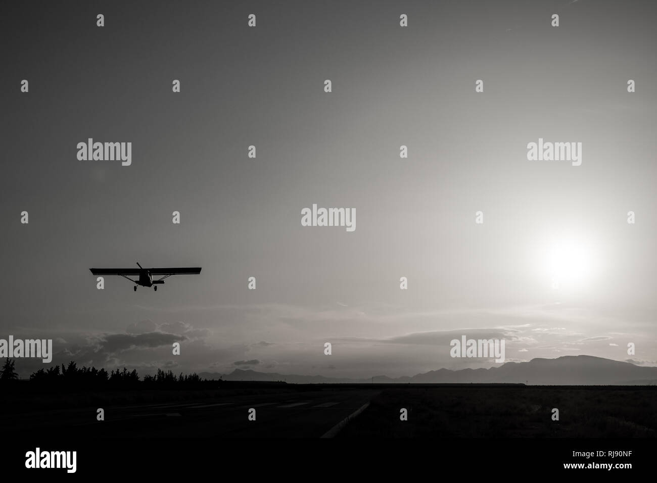 Light aircraft taking off against sunset, backlit Stock Photo - Alamy