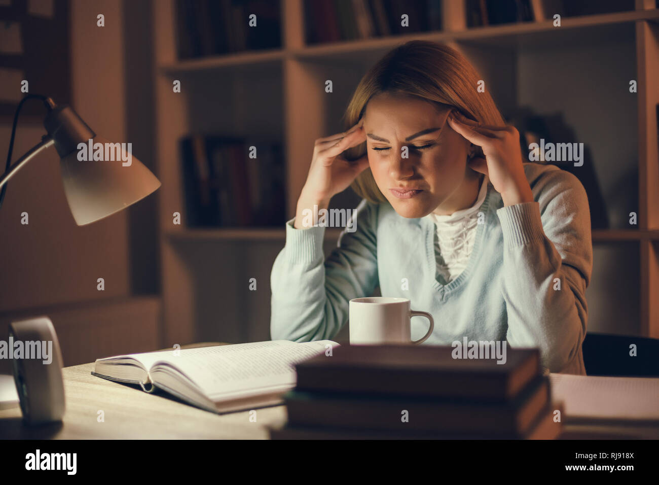 Student is tired of learning. She has headache Stock Photo - Alamy