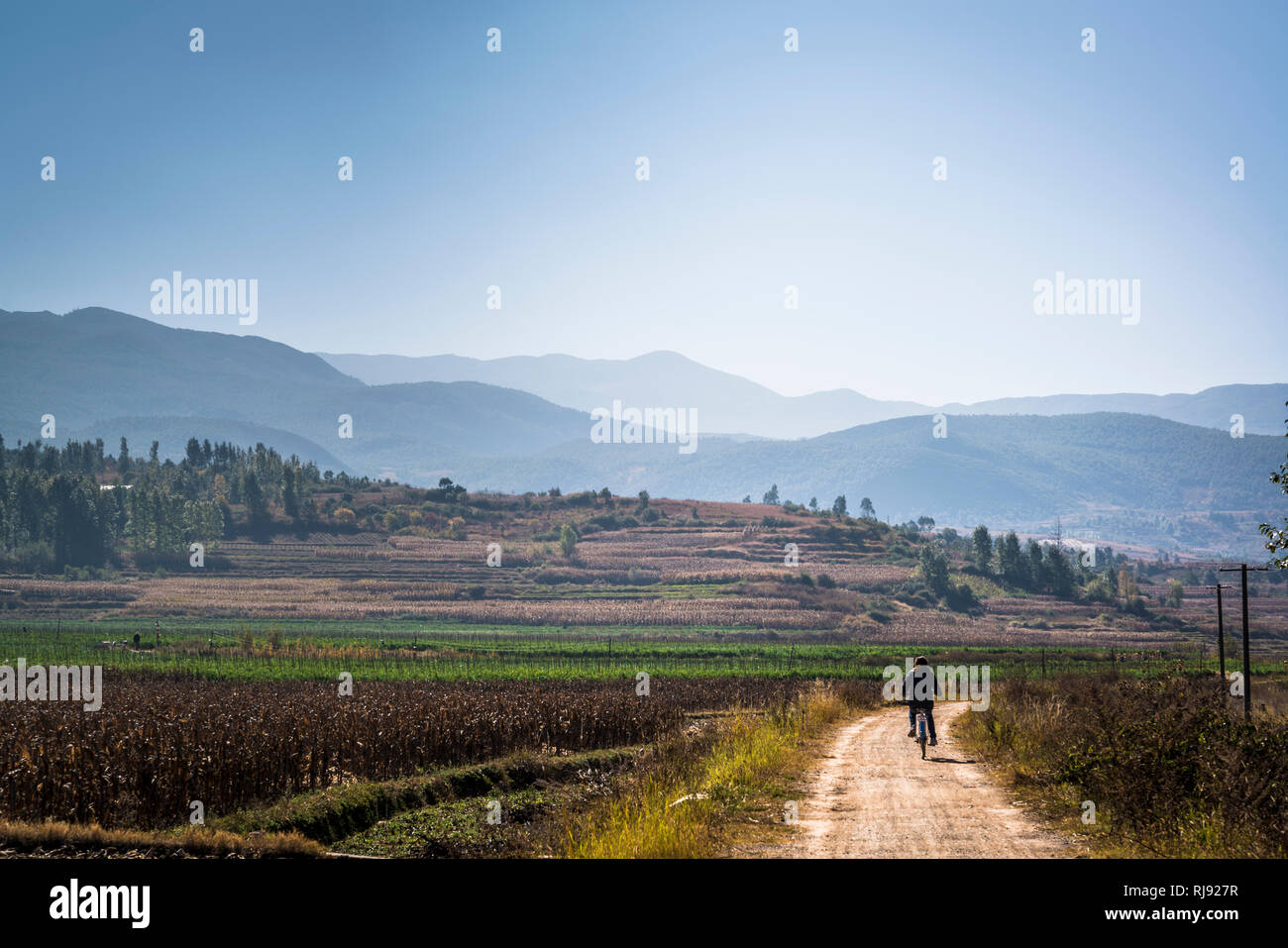 Cyclist riding in the countryside near Shaxi historic market town ...