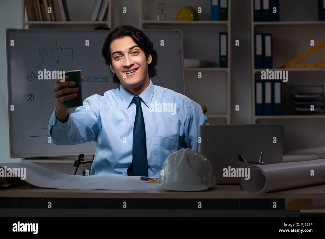 Young male architect working night at office Stock Photo - Alamy