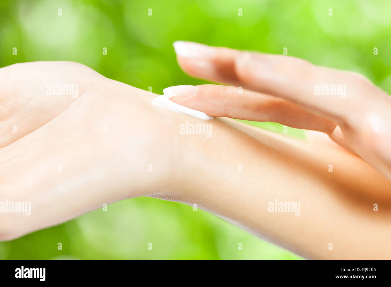 Young woman applying skin cream on her hand Stock Photo - Alamy