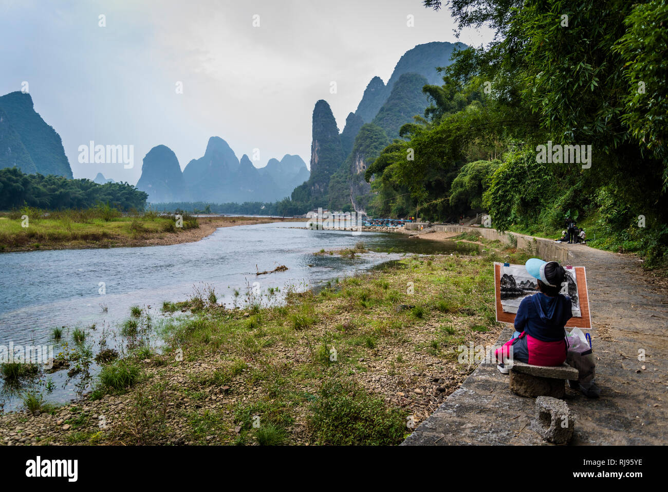 Artist painting the famed landscape of the Li river and limestone karst ...