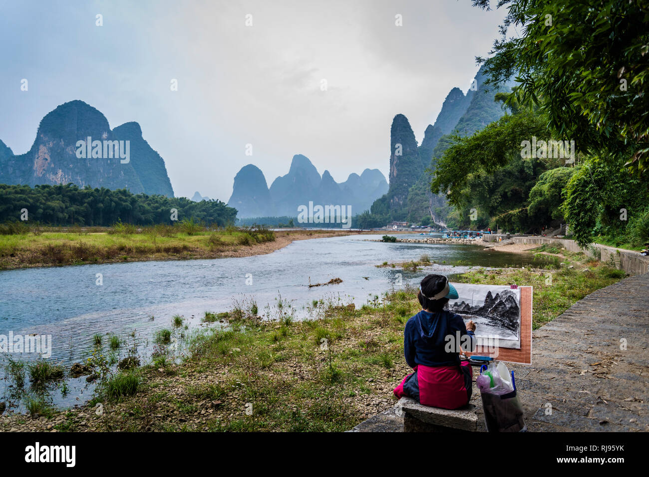 Artist painting the famed landscape of the Li river and limestone karst ...