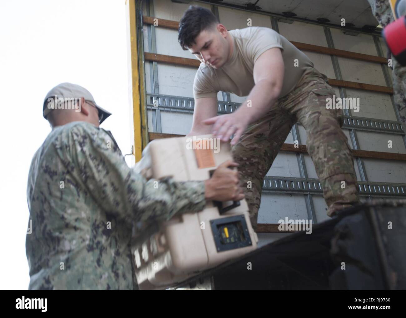 U.S. Navy Sailors and Canadian military forces load gear in preparation ...