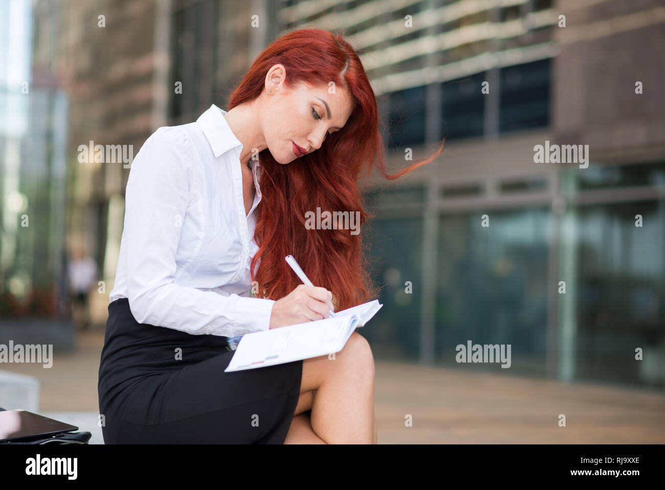 Business woman writing notes Stock Photo - Alamy