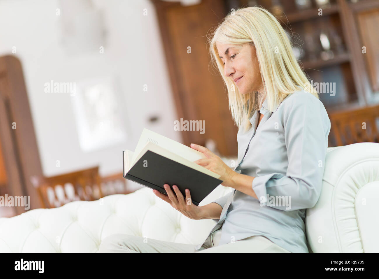 Mature woman reading a book Stock Photo - Alamy