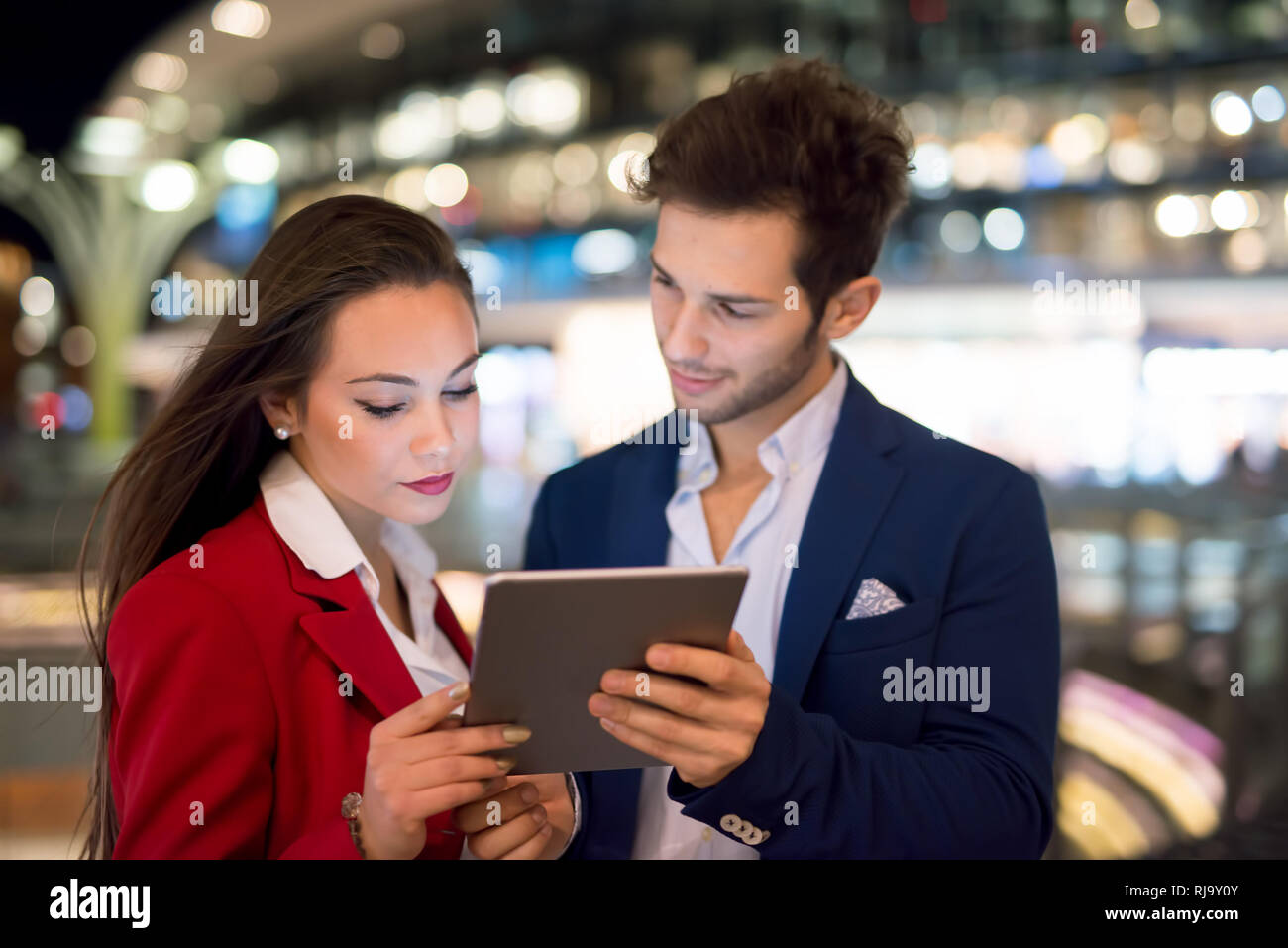 People using tablet at night in a city Stock Photo - Alamy