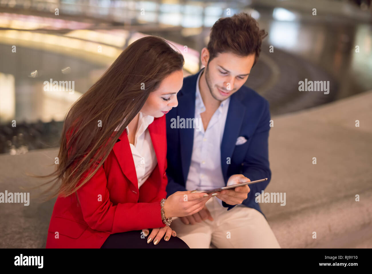People using tablet at night in a city Stock Photo - Alamy