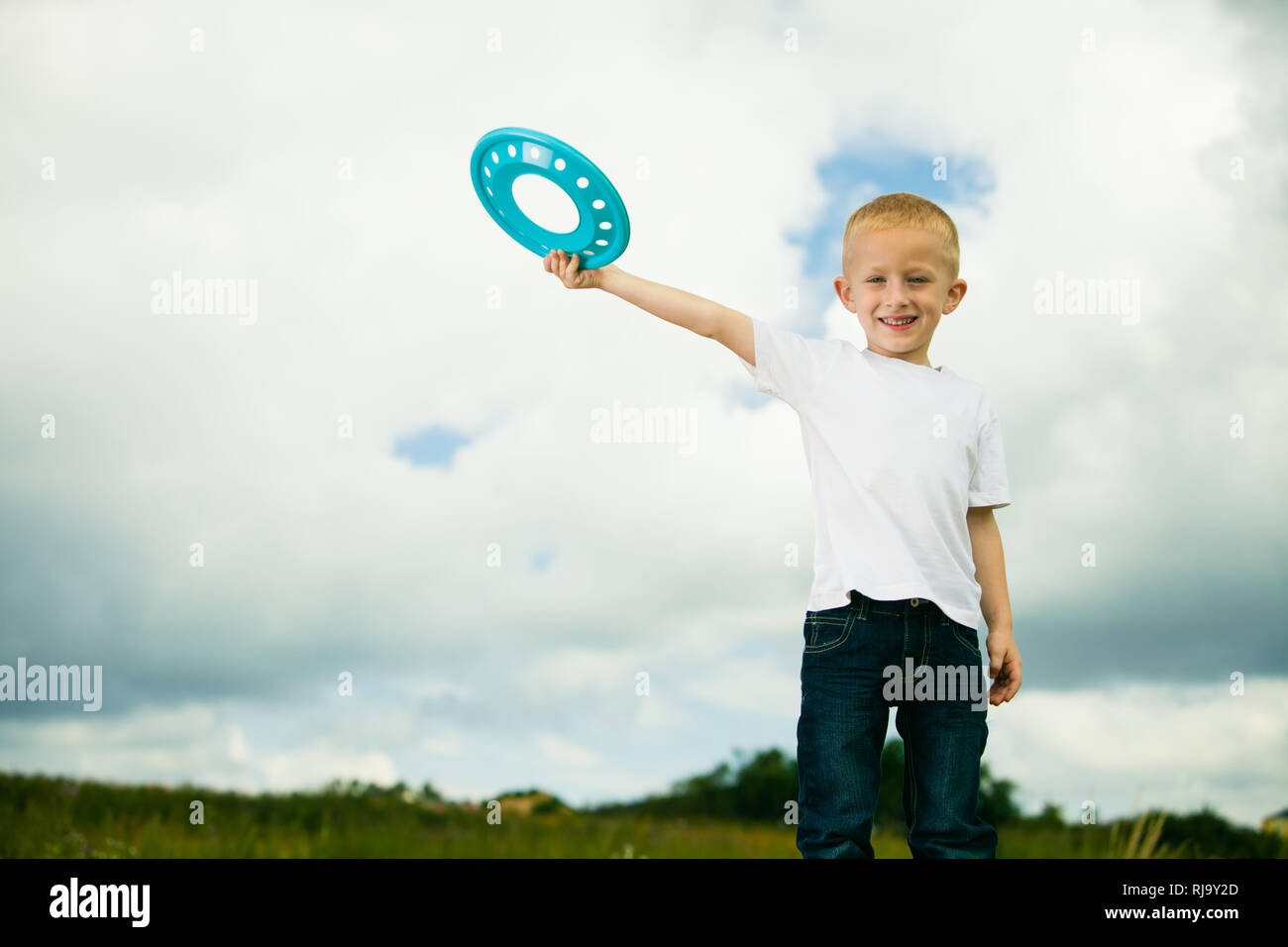 Happy smiling child in playground kid in action boy playing with blue ...