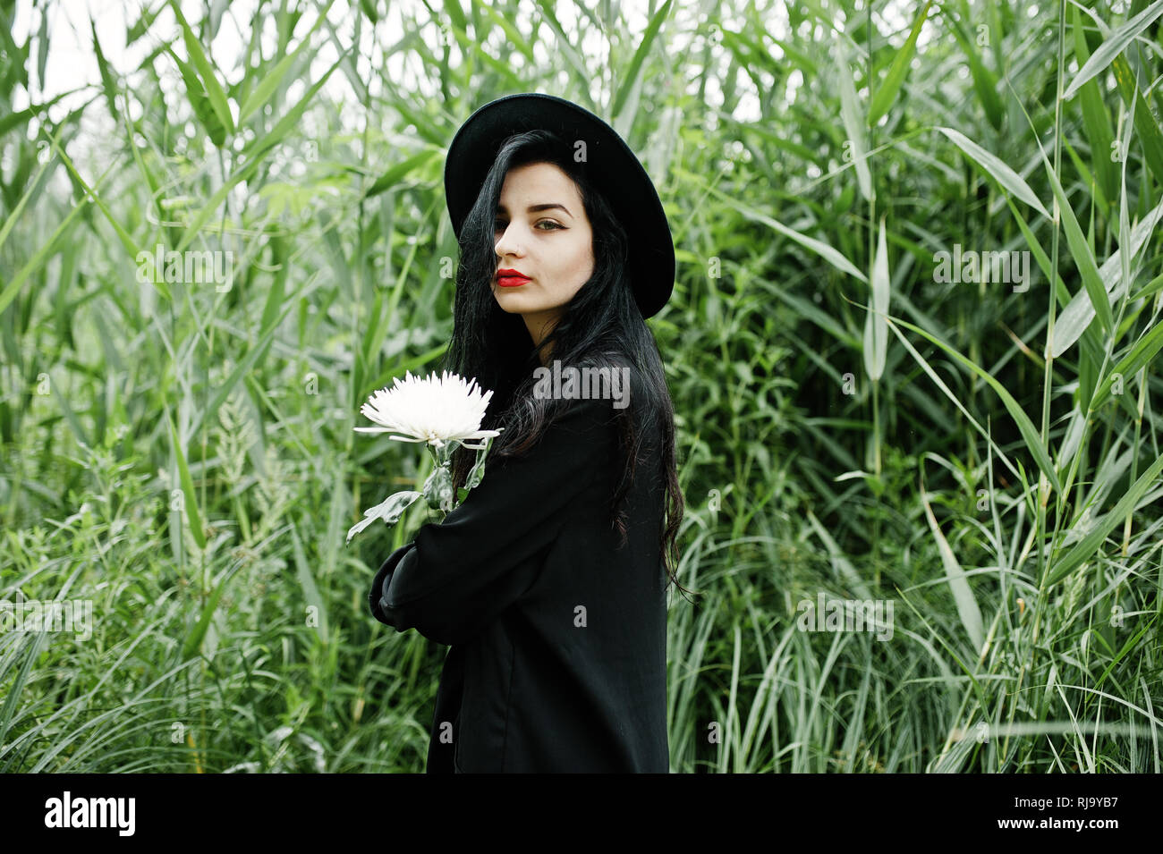 Sensual girl all in black, red lips and hat. Goth dramatic woman on ...
