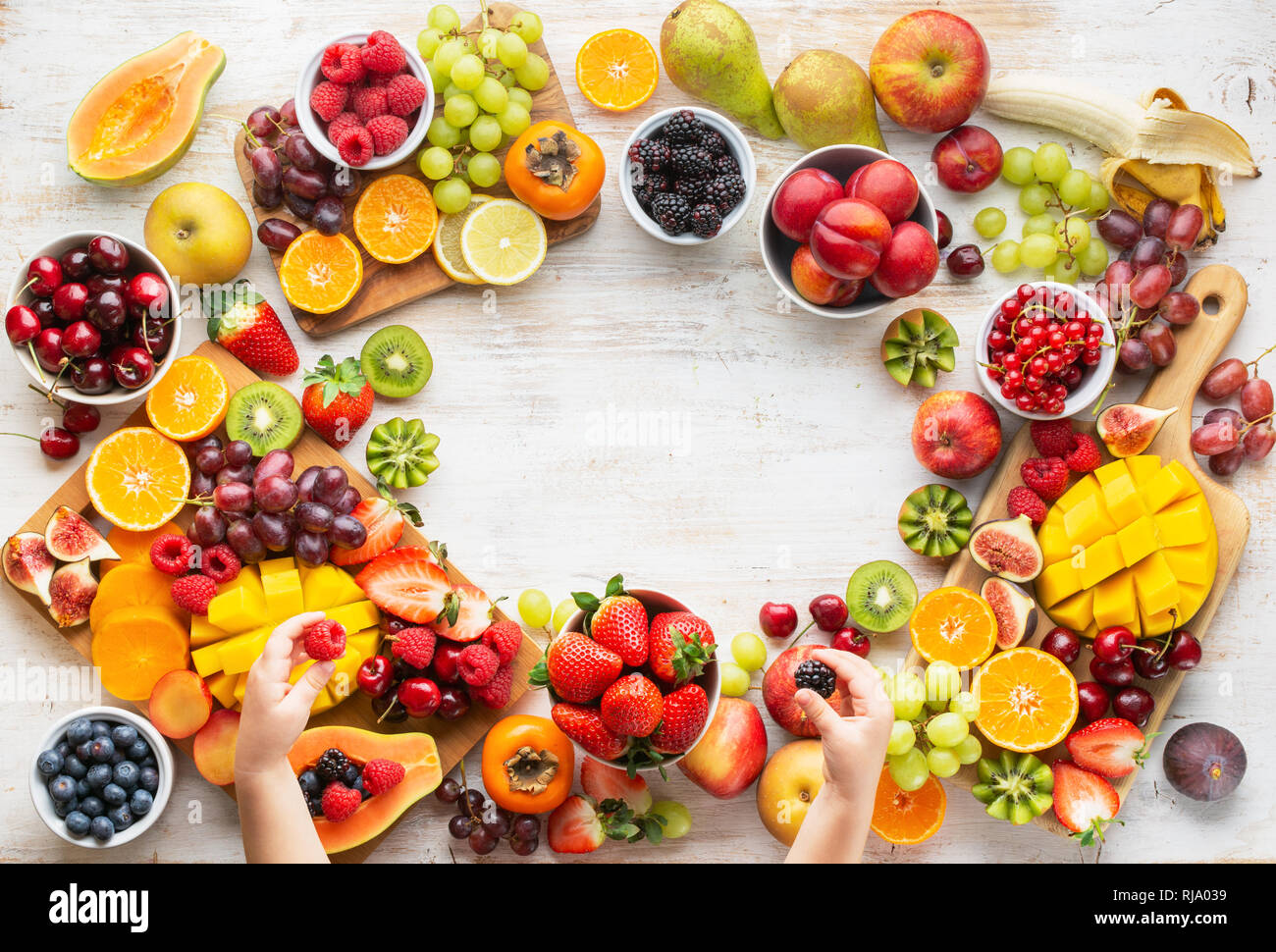 Raw breakfast background, cut fruits, strawberries raspberries oranges ...