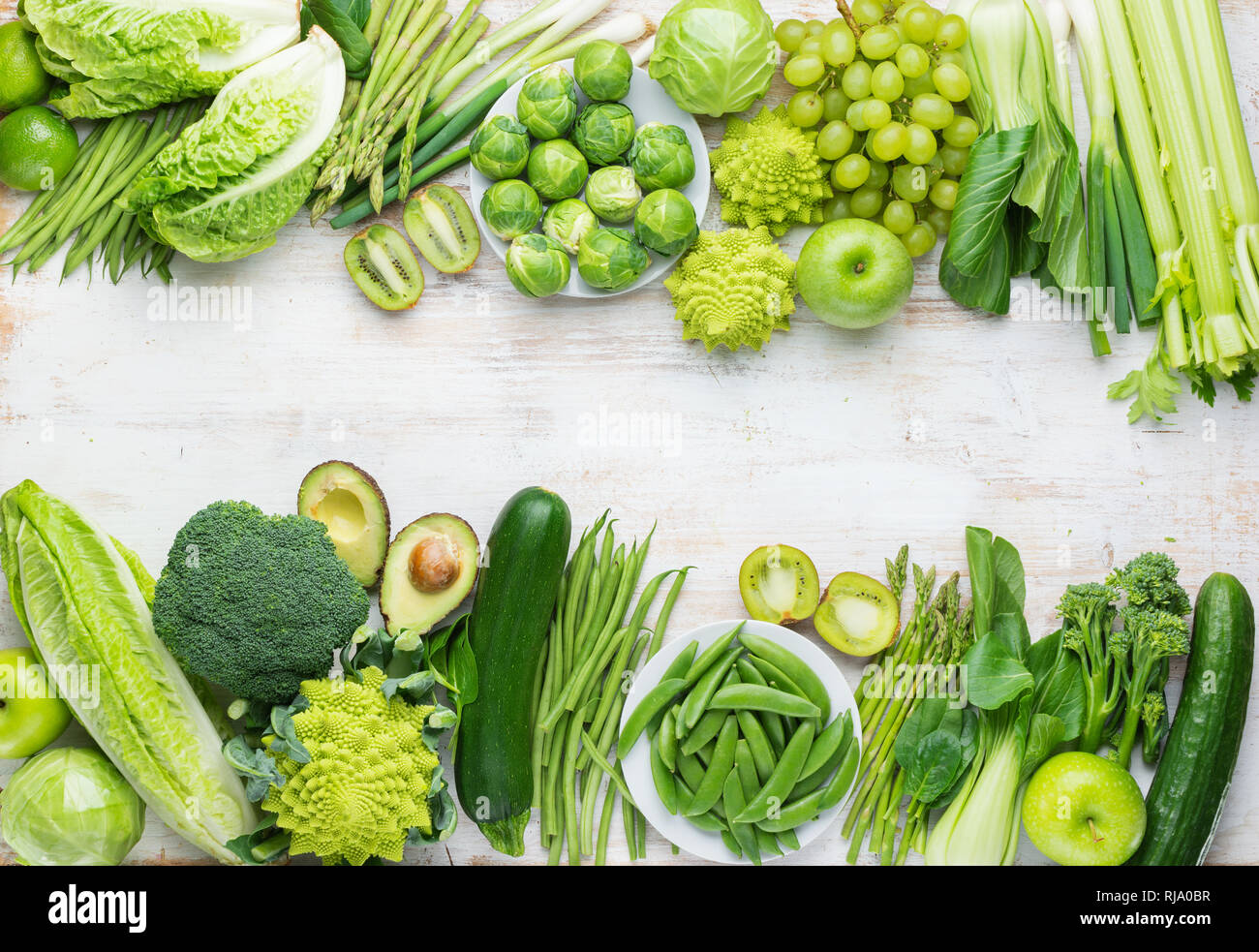 Healthy eating vegan produce. Green vegetables fruits on white table ...
