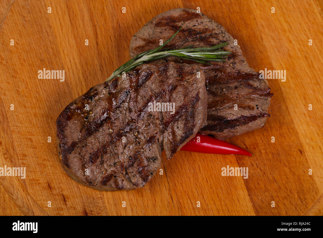 Grilled Fillet Mignon with rosemary and chili pepper over the wooden ...