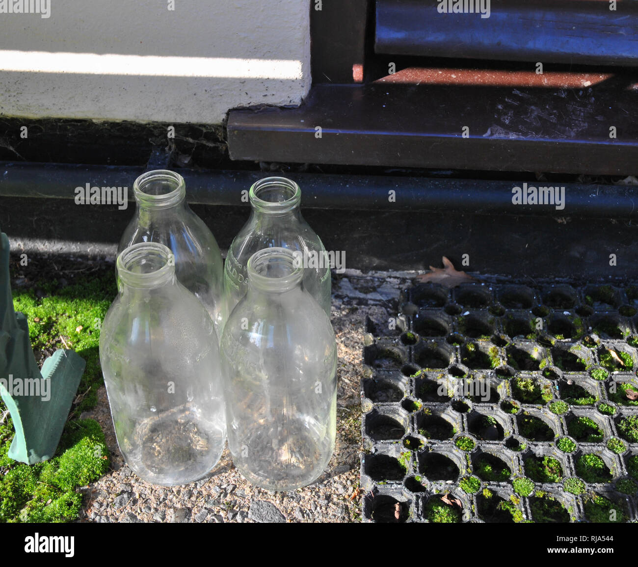 Empty milk bottles awaiting collection on a door step Stock Photo - Alamy