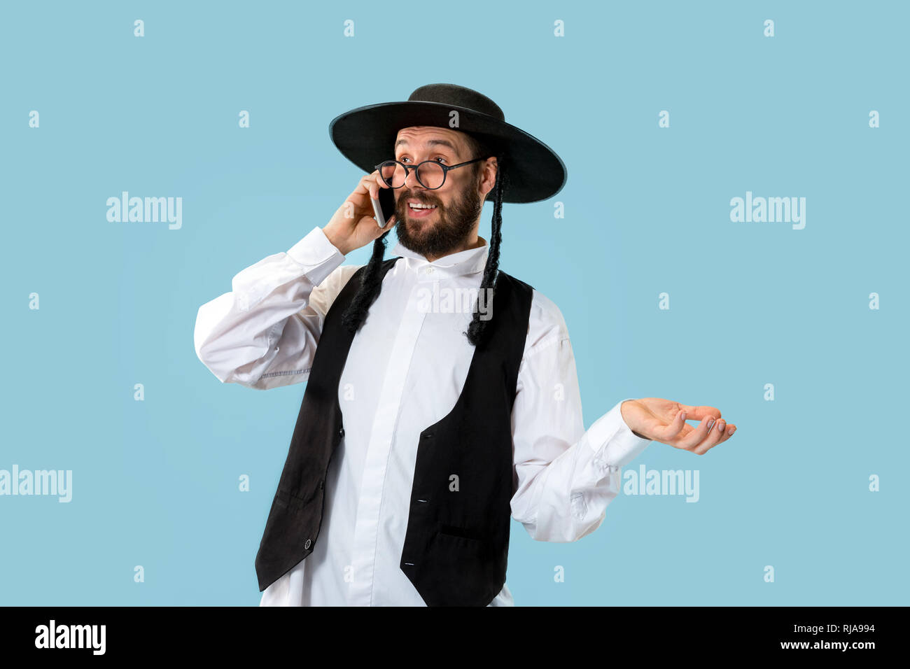 Portrait of a young orthodox Hasdim Jewish man with mobile phone at ...