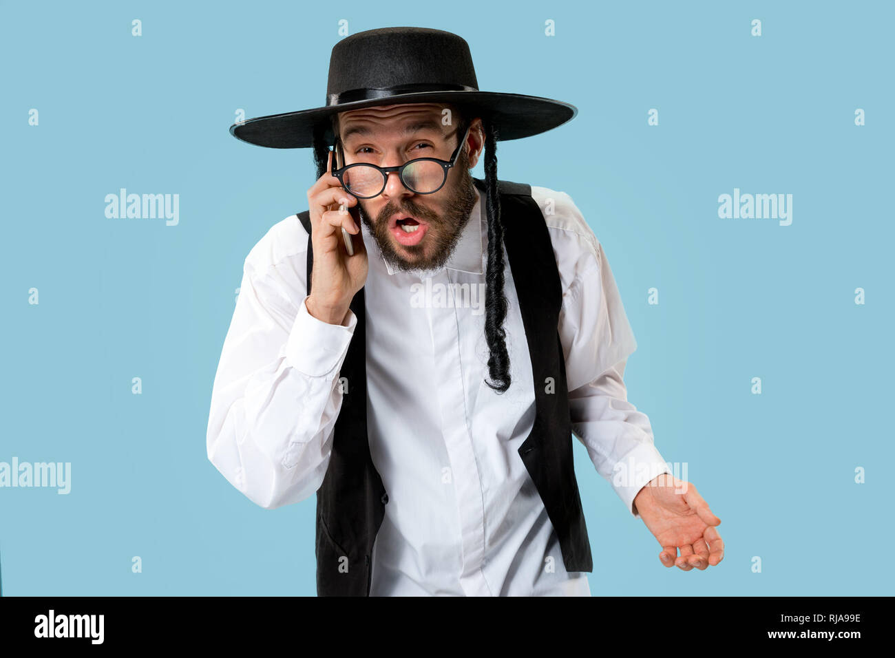 Portrait of a young orthodox Hasdim Jewish man with mobile phone at ...