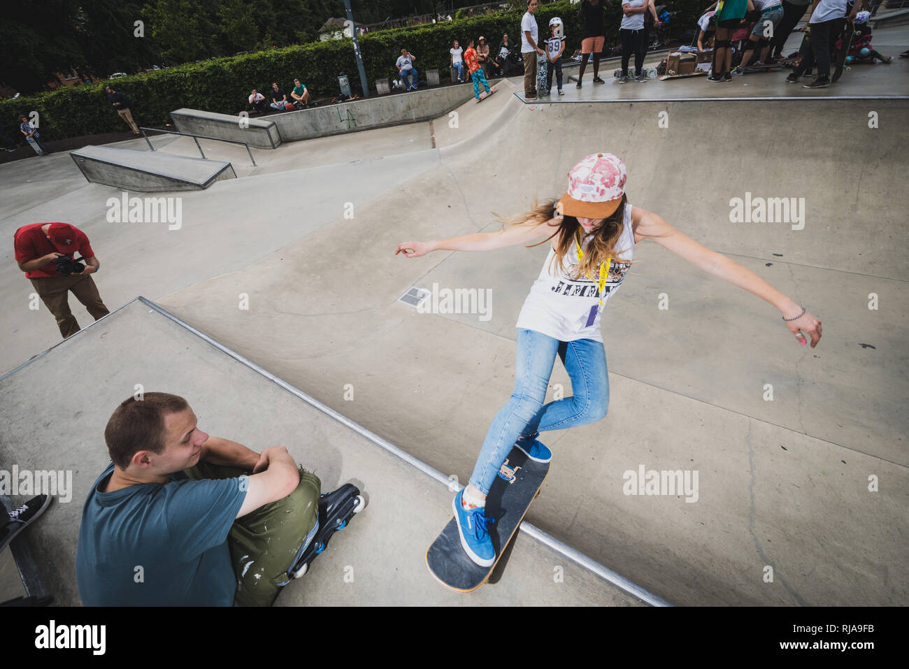 A teenage girl being watched by a boy as she skates at The Level ...