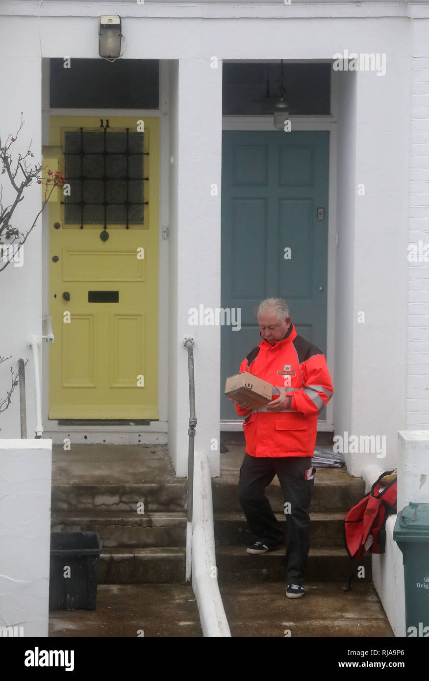 A Royal Mail postman delivers post and parcels to residential ...