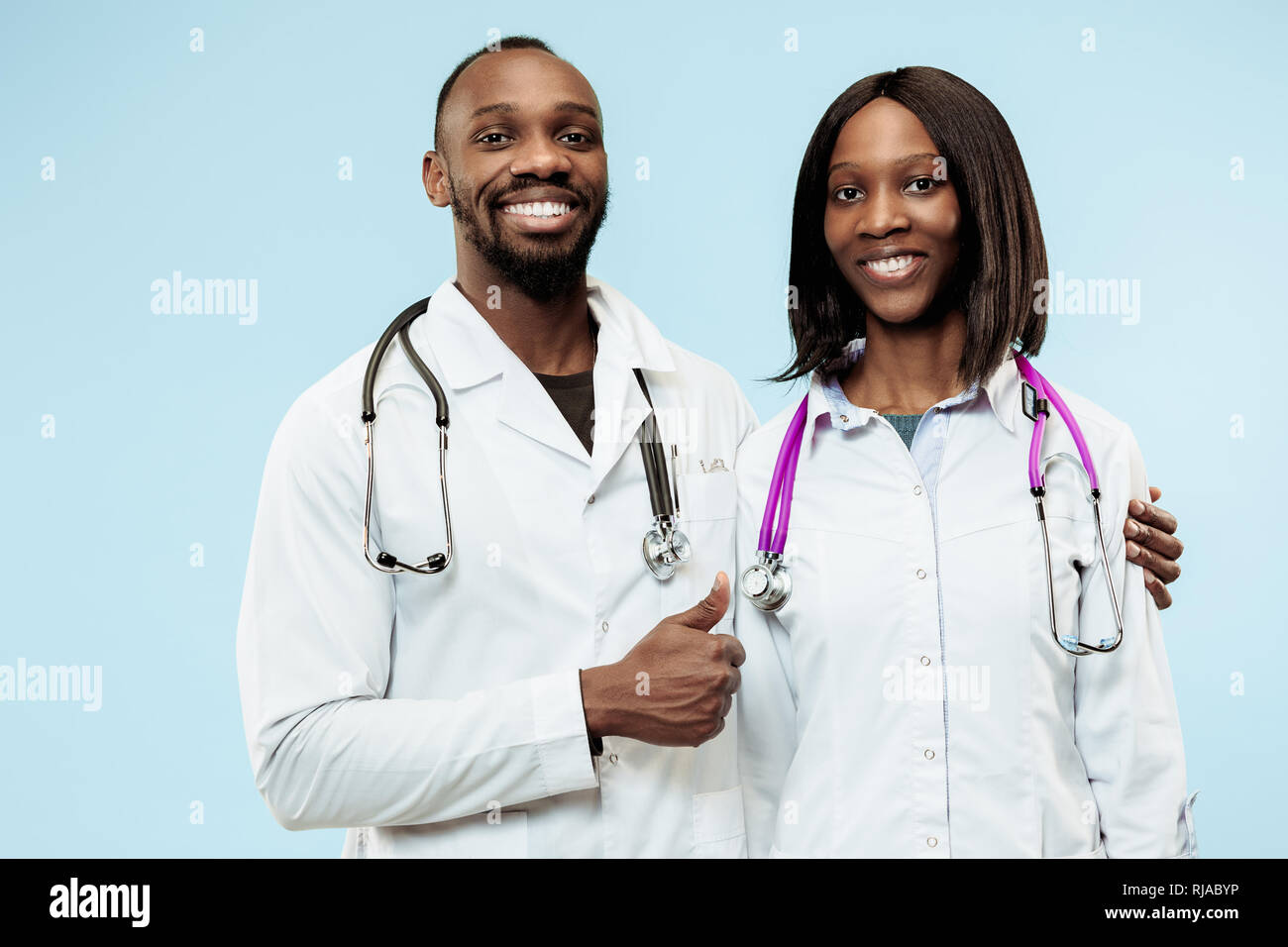 The female and male smiling happy afro american doctors on blue ...