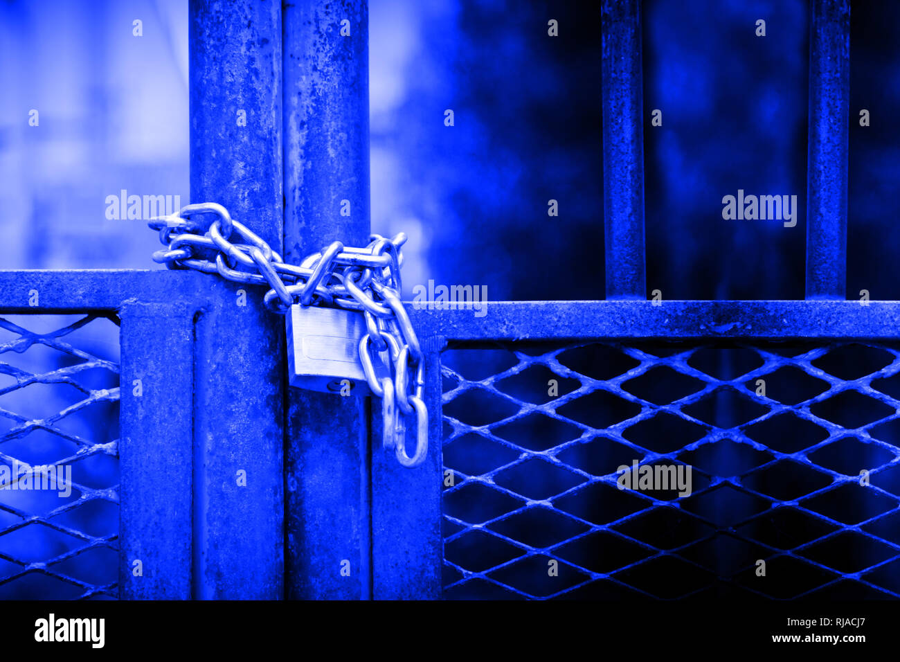 Rusty metal gate of a factory closed with padlock - toned image Stock ...