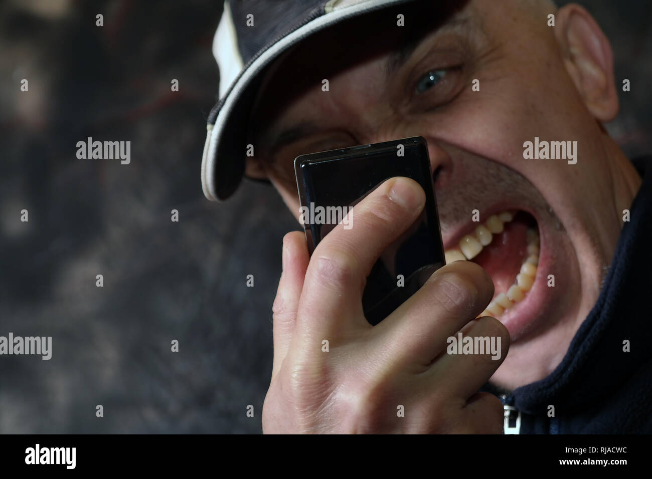A man seems mad shouting into mobile phone, studioextremely emotional ...