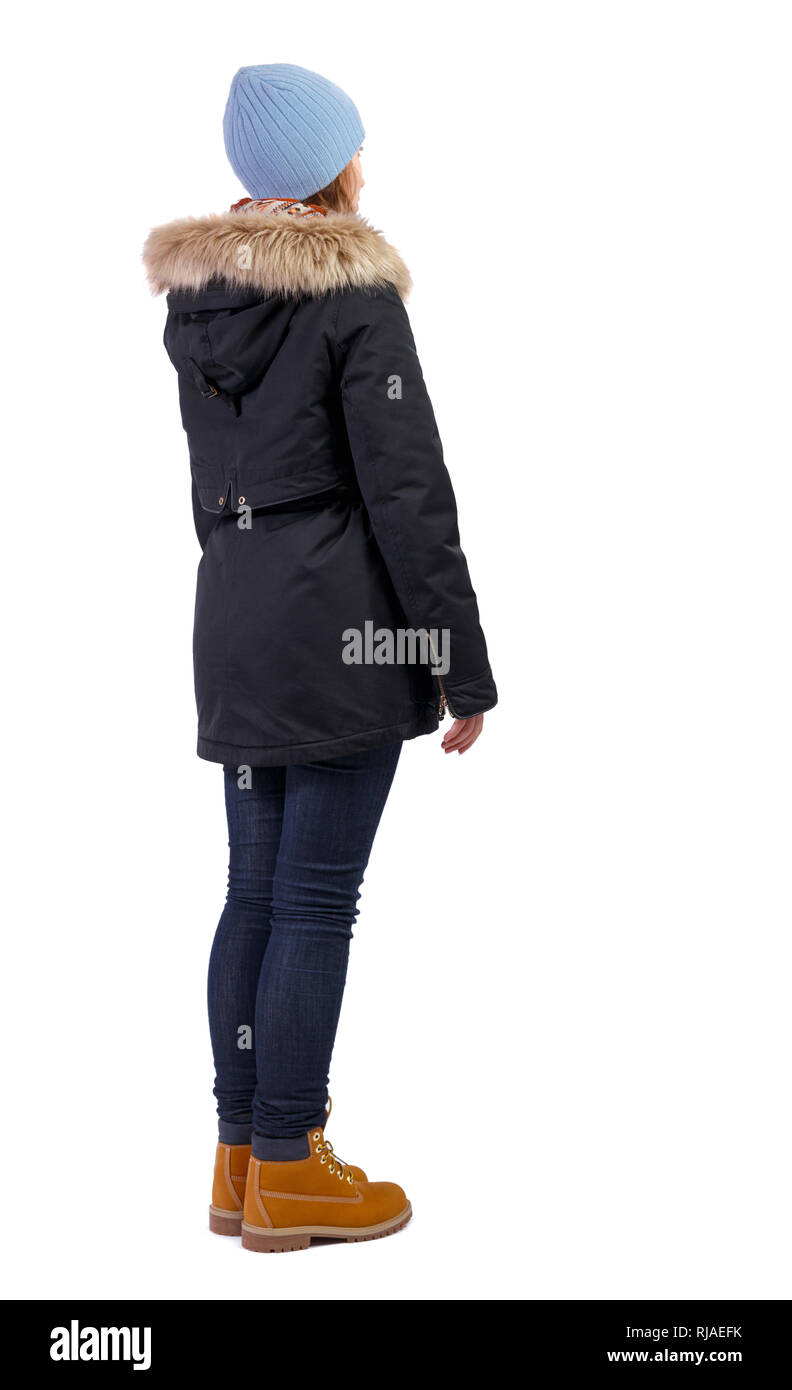 Back view woman in a black winter jacket with fur and blue hat ...