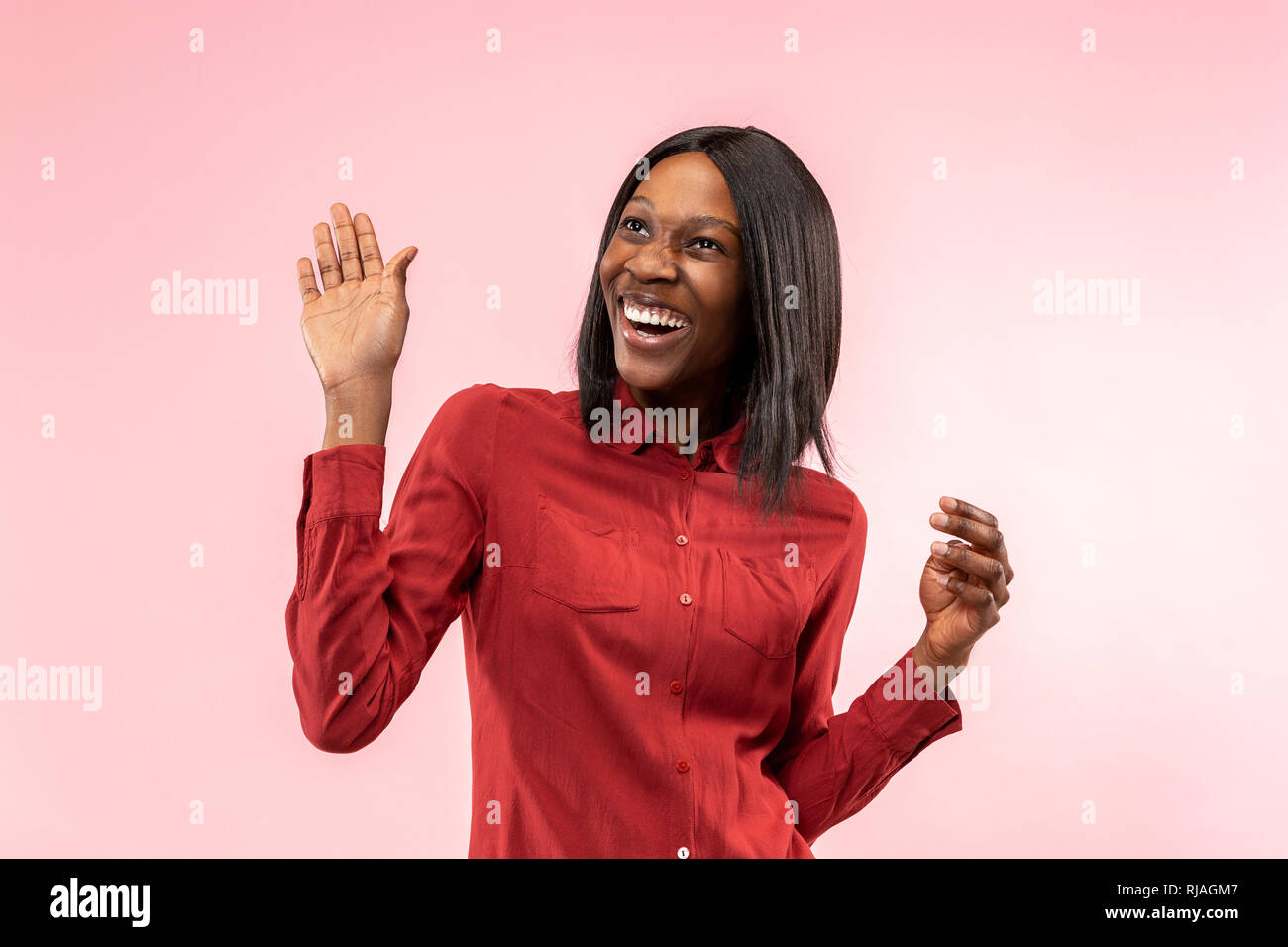 Happy business woman standing and smiling isolated on red studio ...
