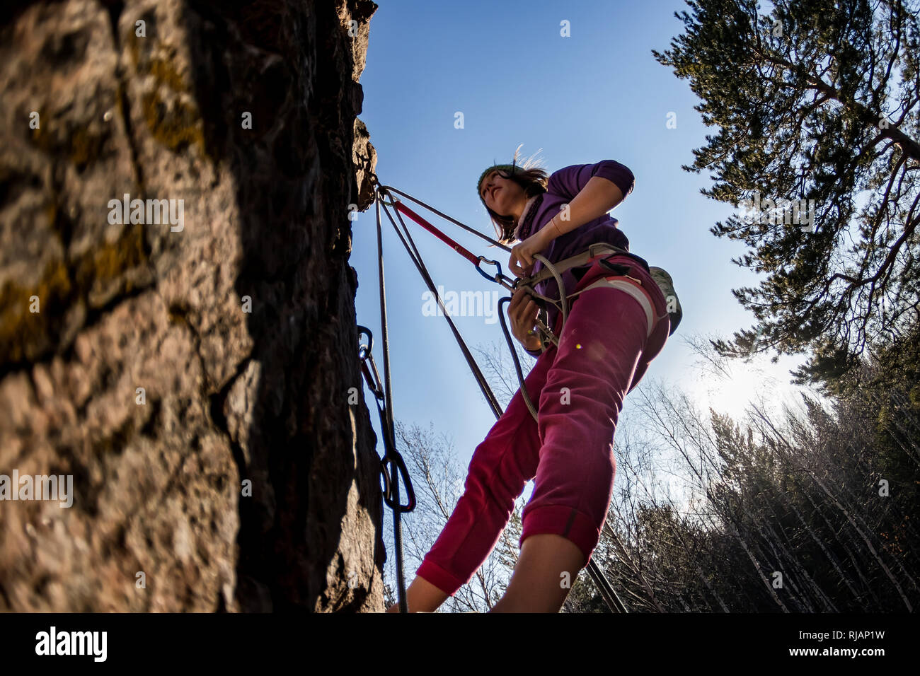 rock-climber girl crying in pain hanging on a rope with a sad face when ...