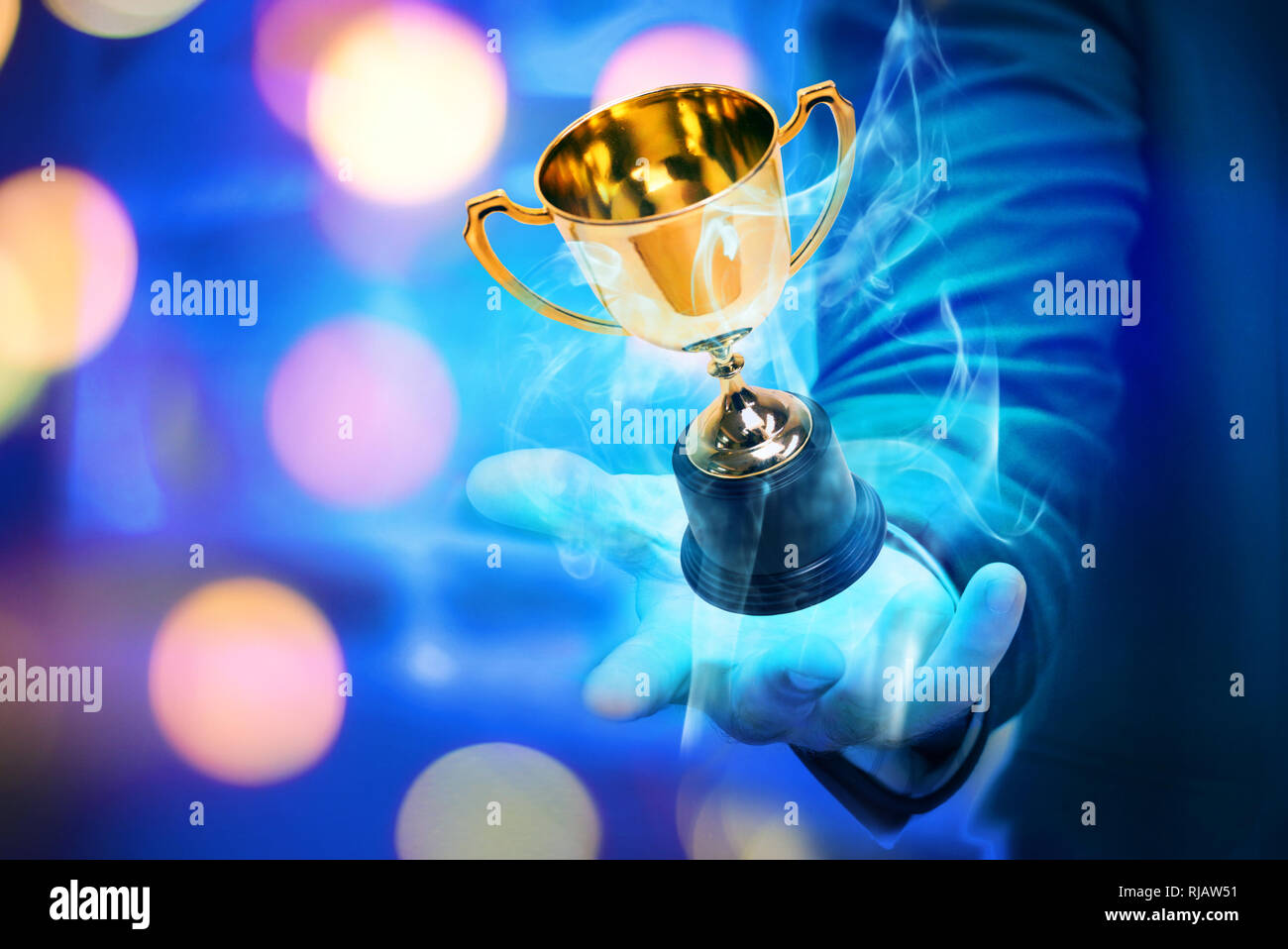 Trophy and particle smoke effect on winner 's hand in party background ...