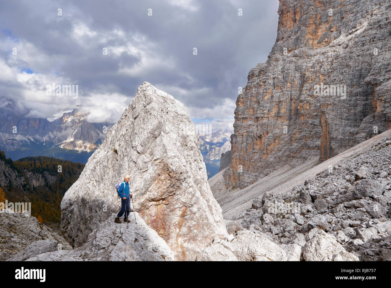 Female walker standing beside a huge boulder in Val de Formin, near ...