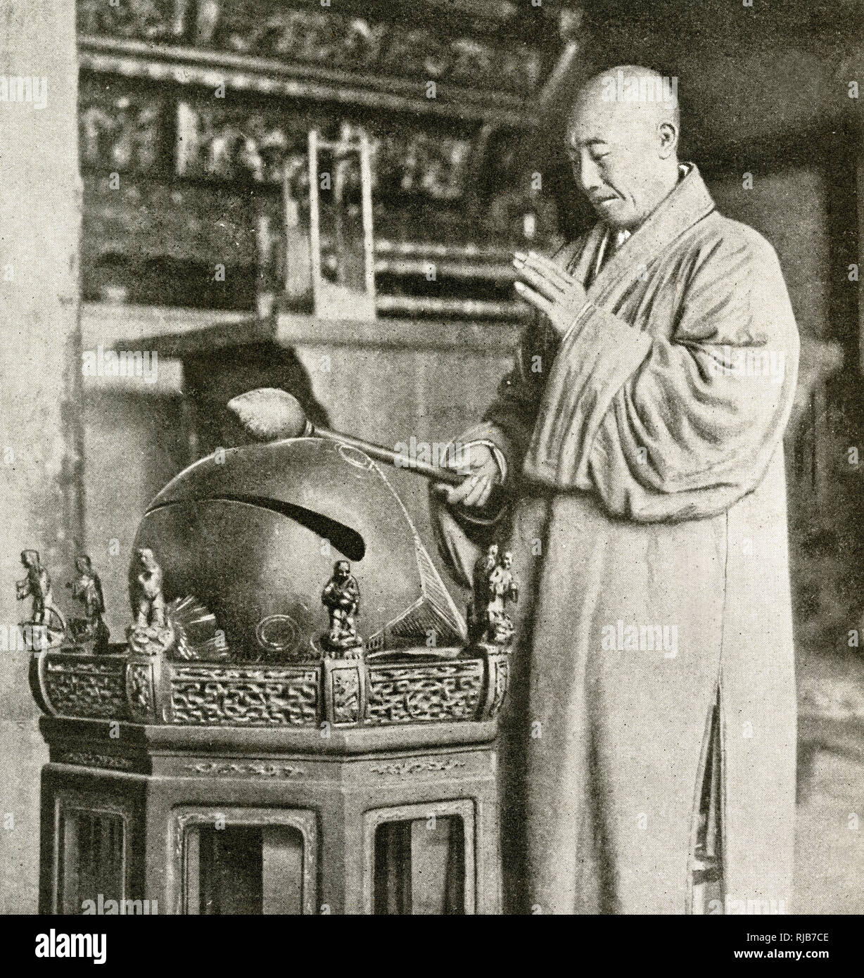 Buddhist priest striking a temple bell, China, East Asia Stock Photo ...