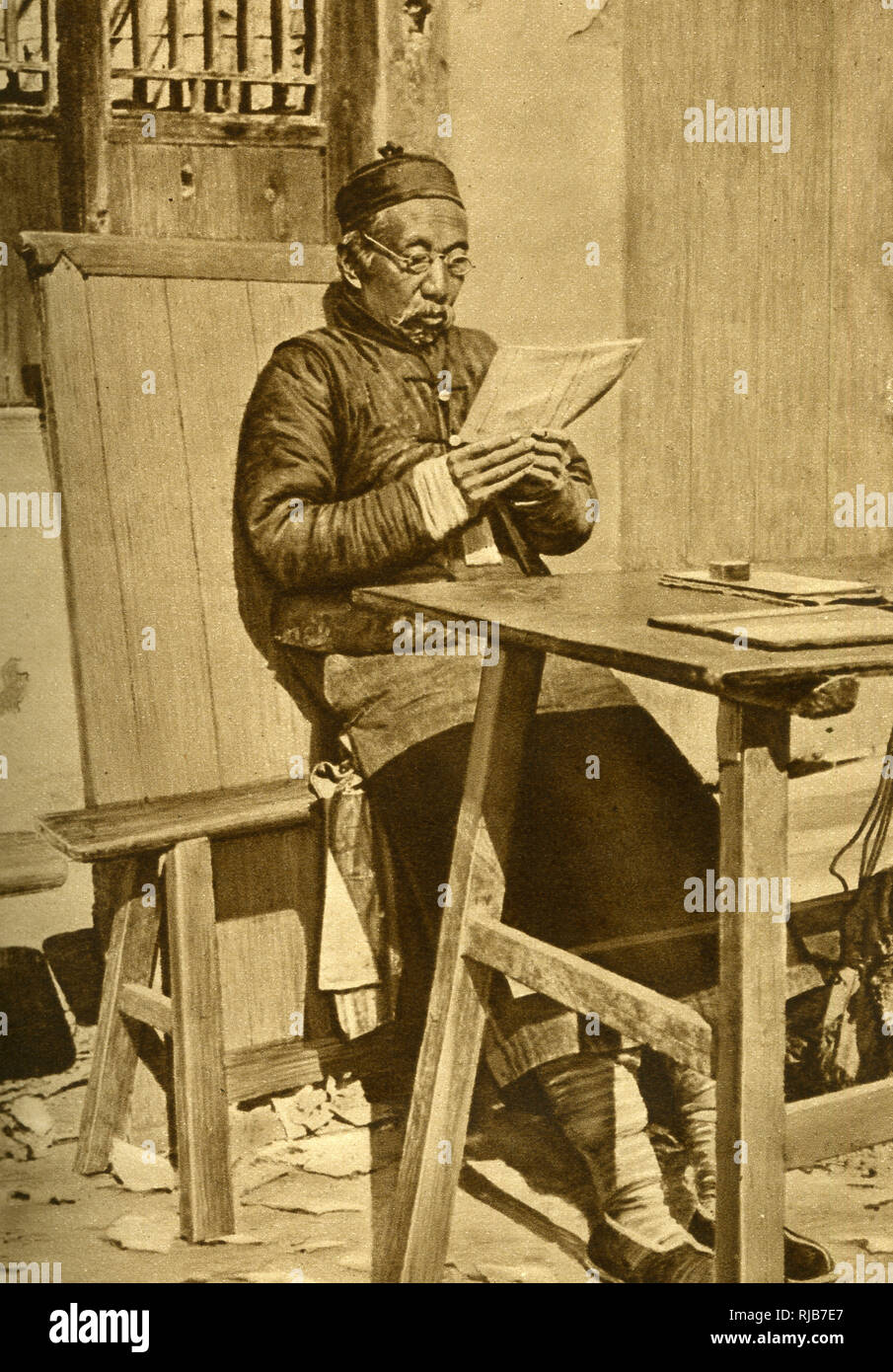 Elderly man reading at a table, Shanghai, China, East Asia Stock Photo ...