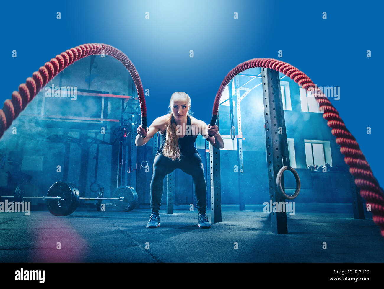 Woman with battle ropes exercise in the fitness gym. The sport, rope ...
