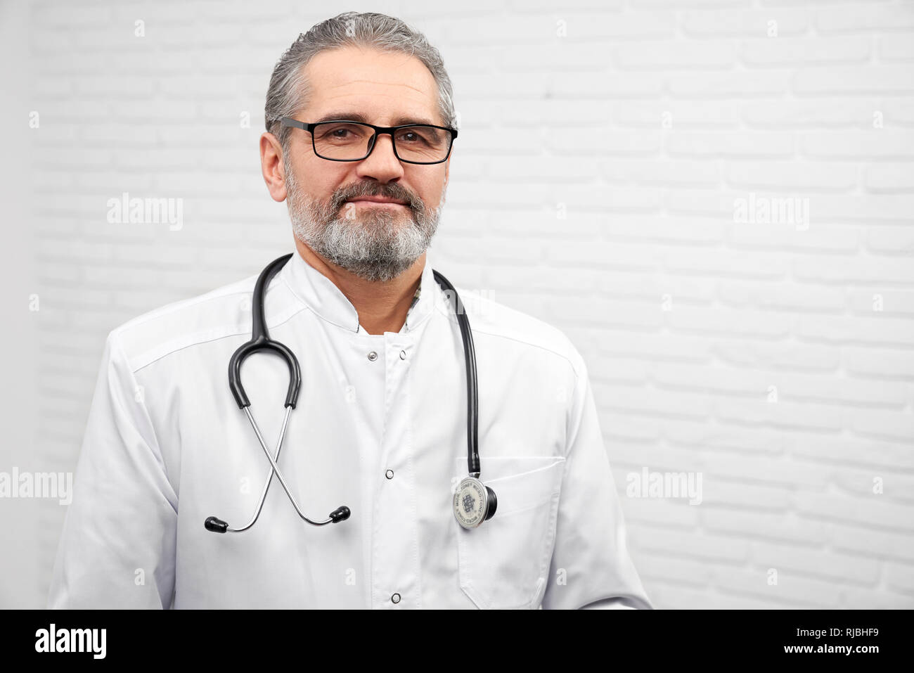 Professional ENT doctor looking at camera and posing in studio with ...