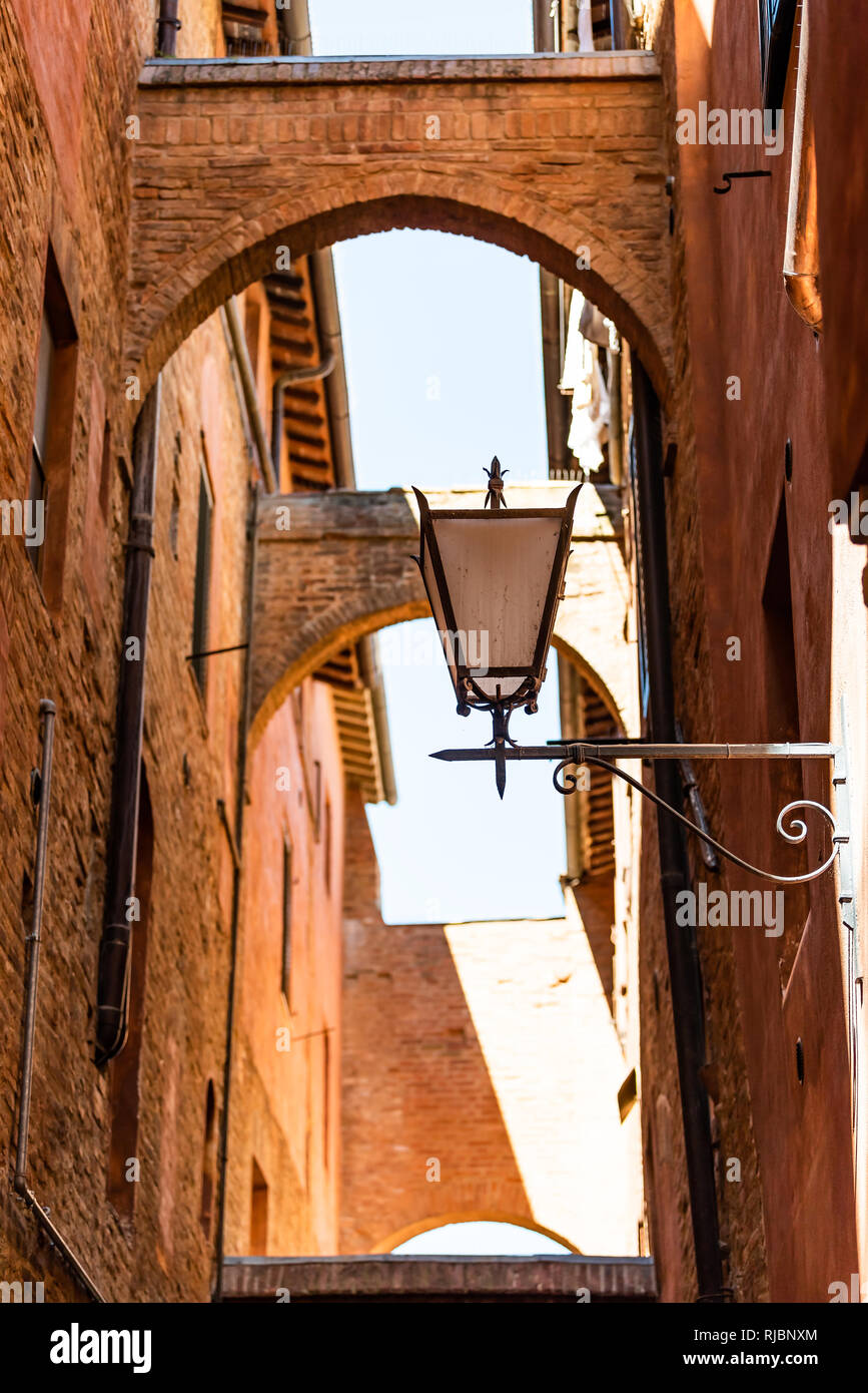 Siena, Italy narrow alley street in historic medieval old town village ...