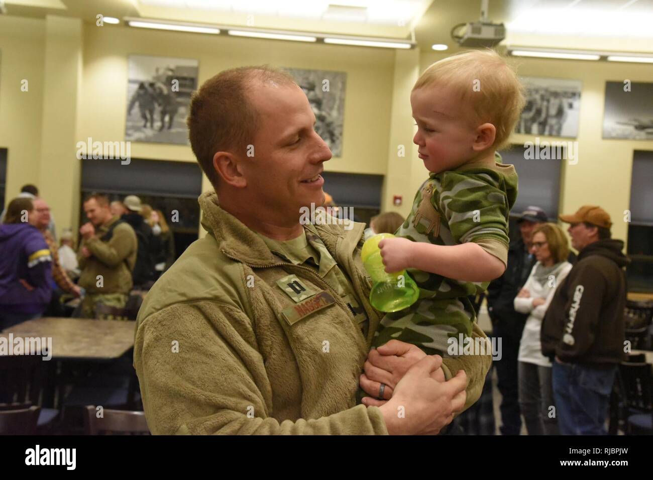 Capt. Brent Nasset, of the 119th Civil Engineer Squadron, holds his son ...