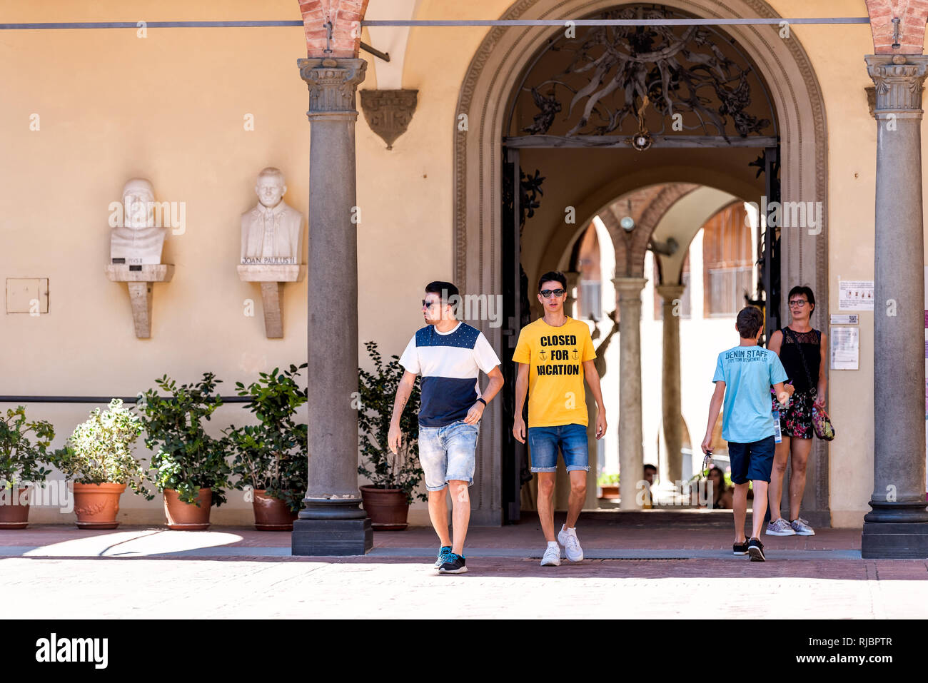 Siena, Italy - August 27, 2018: Young people walking by arch on street ...