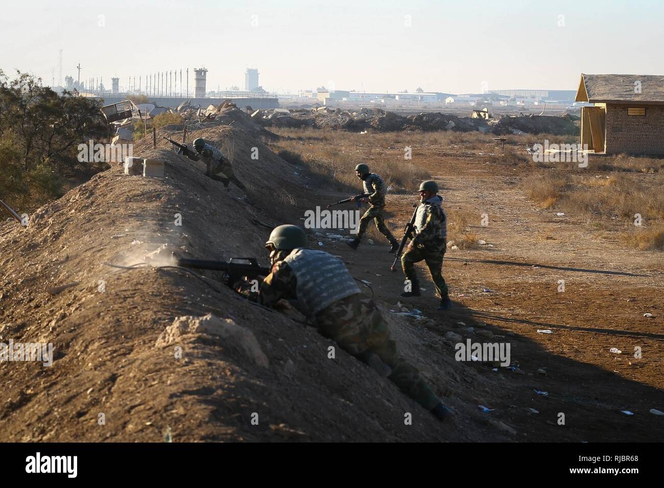 Iraqi Soldiers attached to the 57th Brigade use a berm for cover while ...