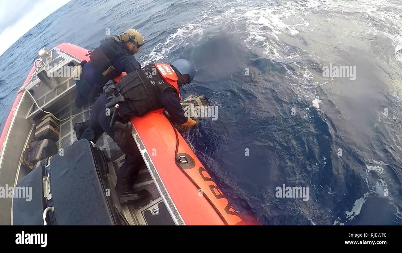A Coast Guard Cutter Mohawk boat crew pulls bales of cocaine from the ...