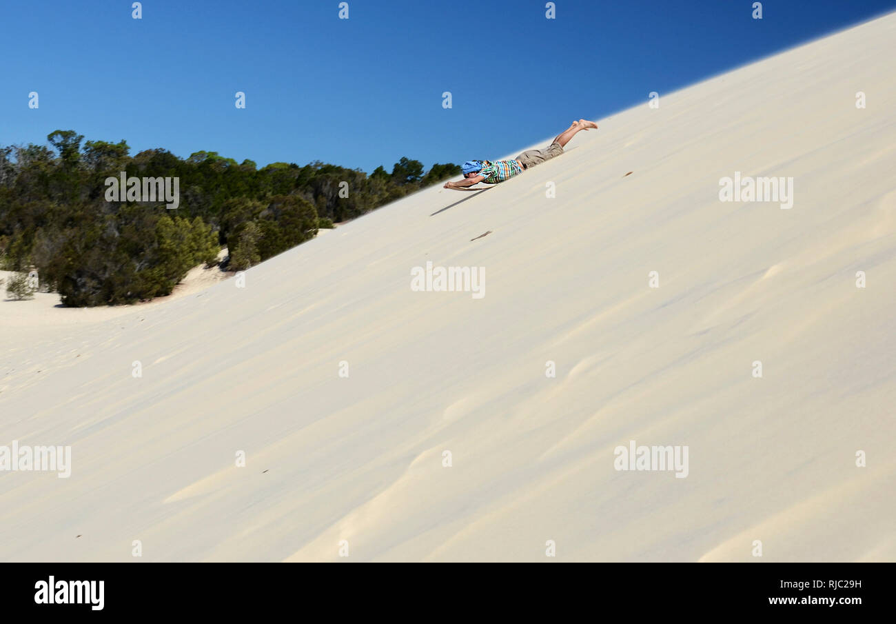 Man sandboarding on a sand dune, Cairns, Australia Stock Photo - Alamy