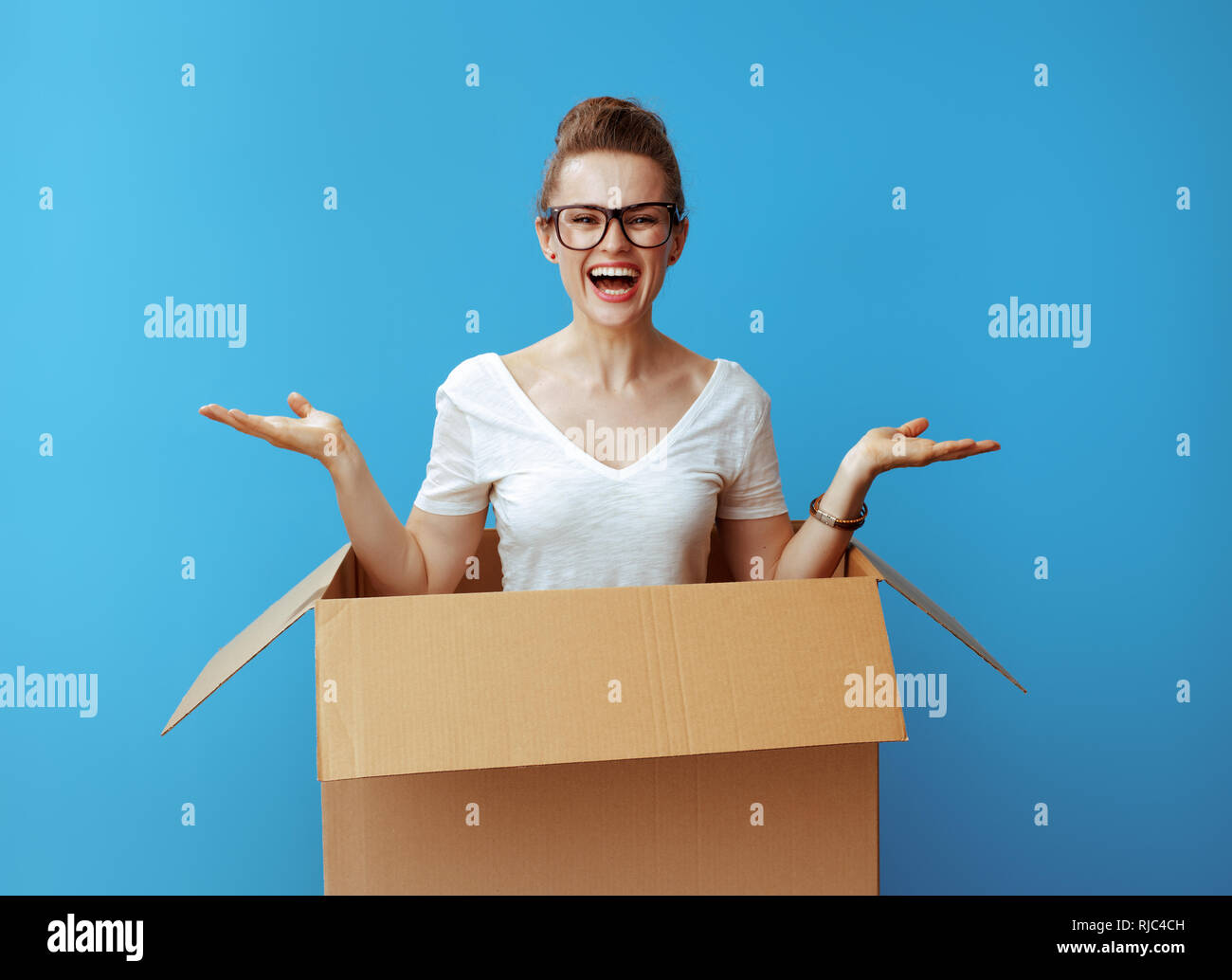 happy modern woman in white t-shirt presenting something on empty palm ...