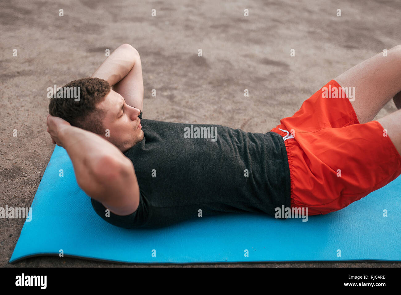 Young guy on rug. Trains twisting, abdominal muscles. Strengthening ...