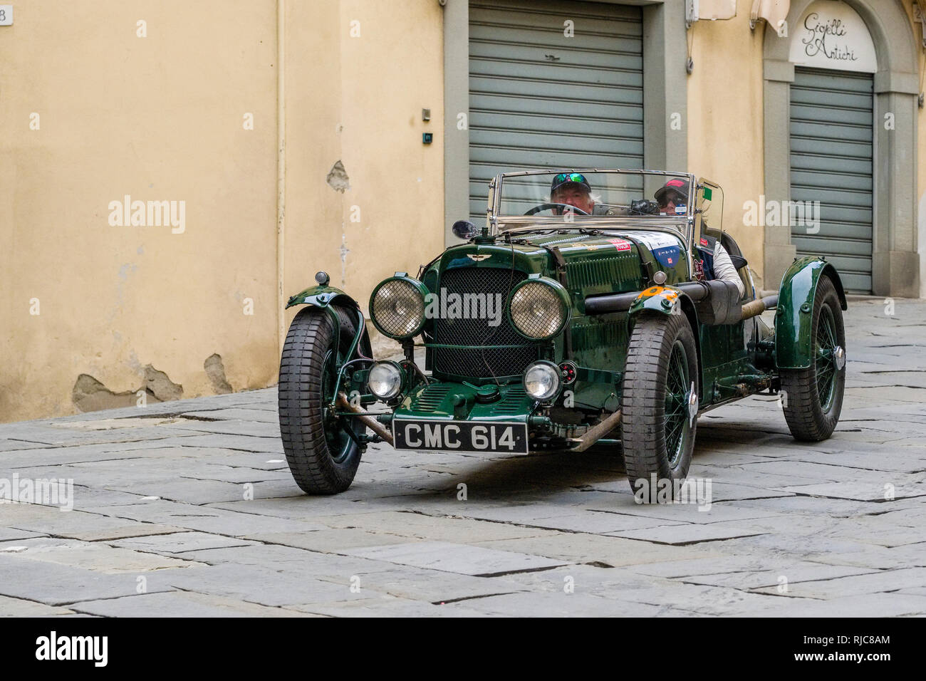 A vintage car, joining the rallye Mille Miglia, driving through the ...