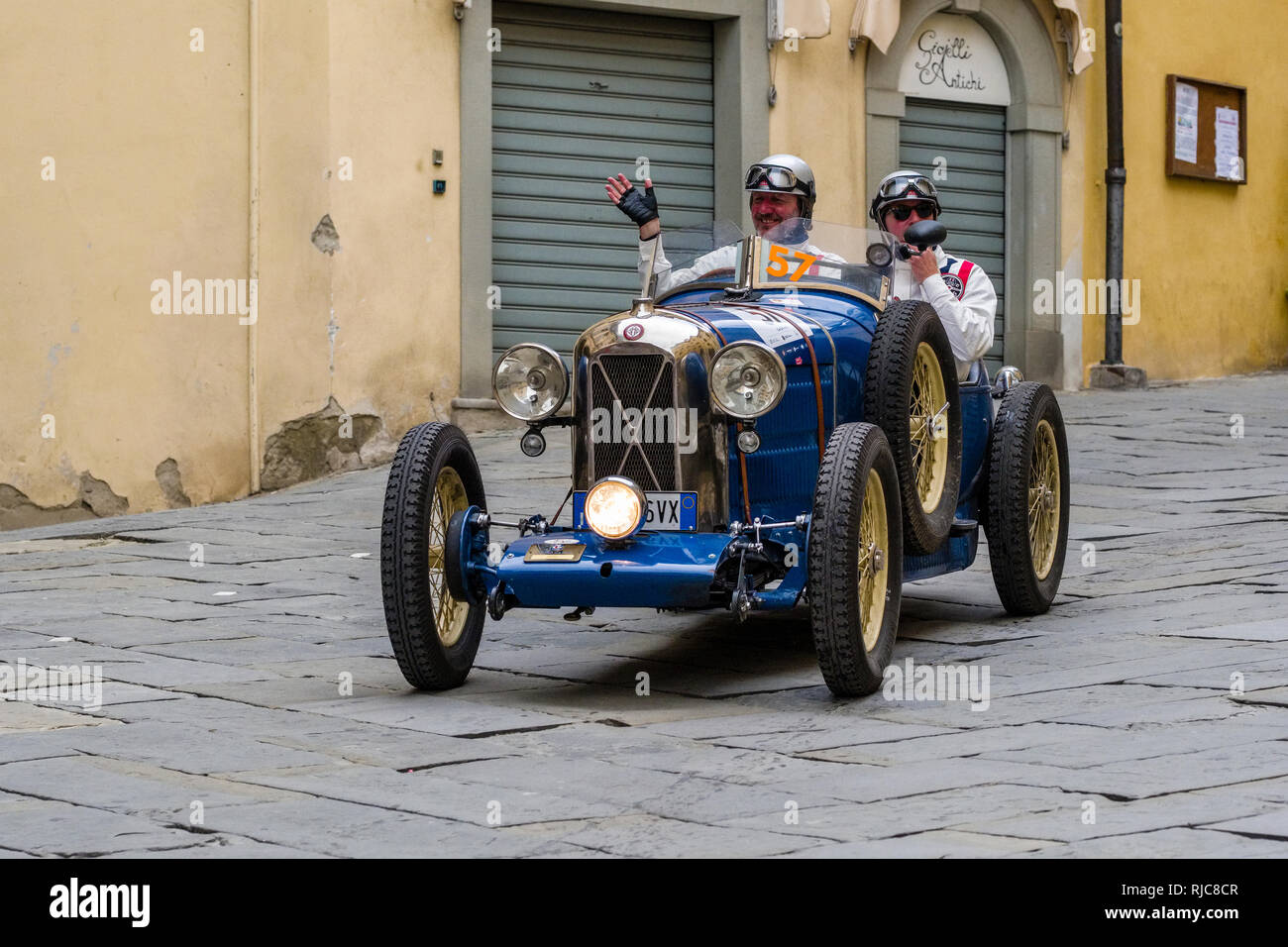 A vintage car, joining the rallye Mille Miglia, driving through the ...