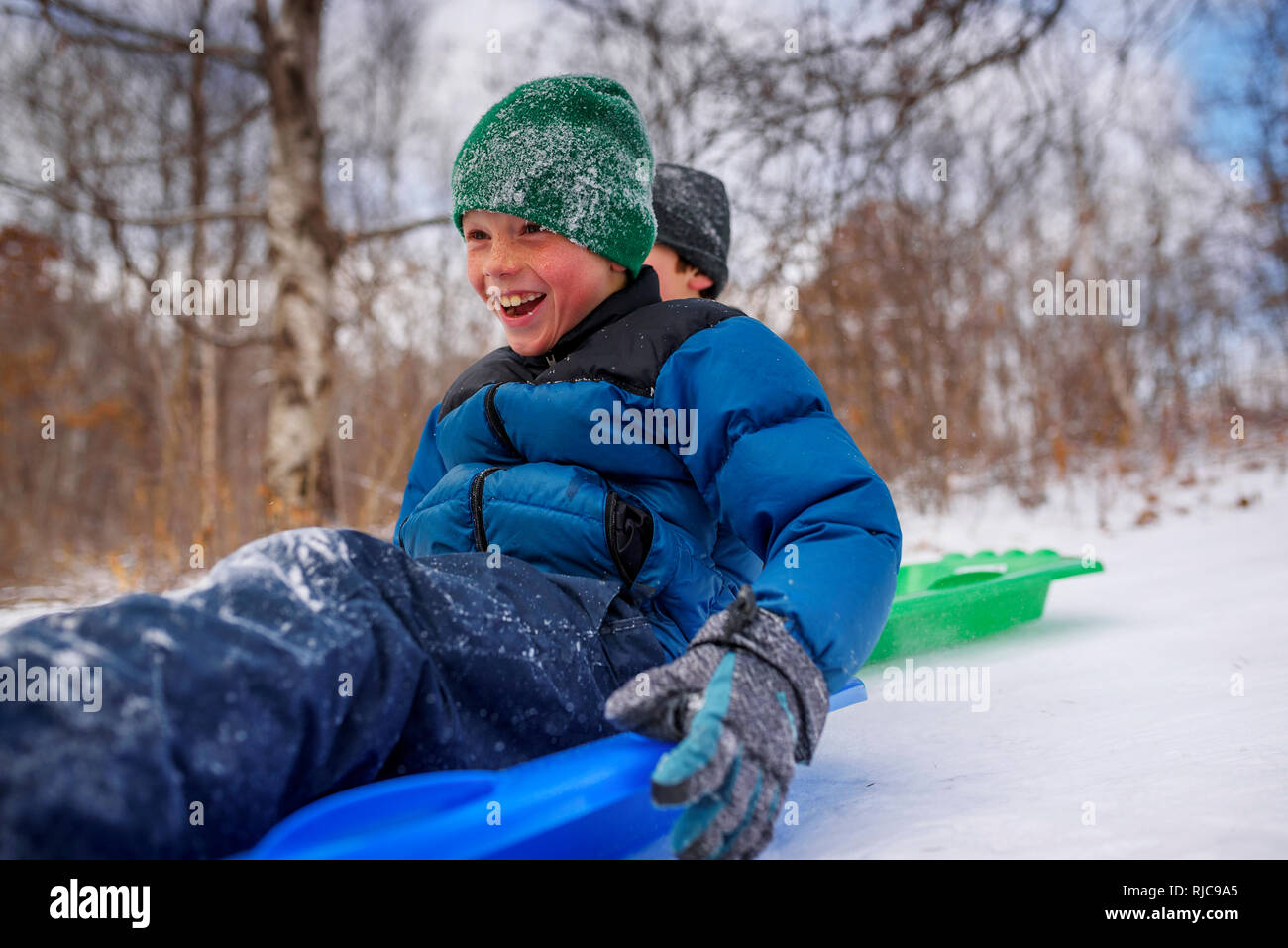 Two boys on a sledge laughing, Wisconsin, United States Stock Photo - Alamy