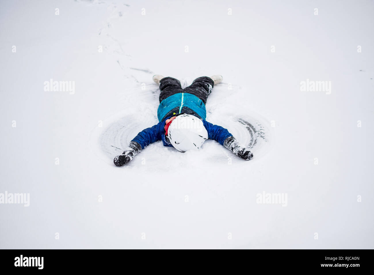 Boy lying in snow making a snow angel, Wisconsin, United States Stock ...