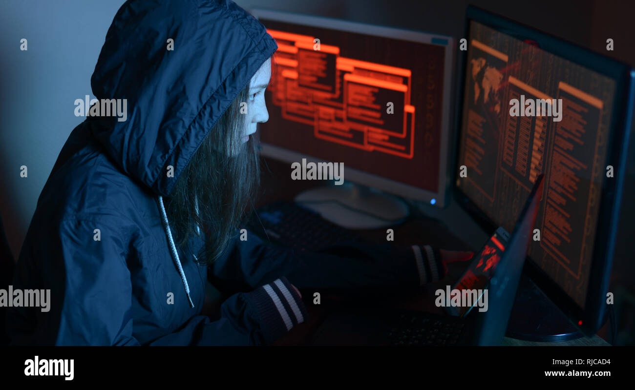 Girl hacker is pointing her finger at the display indicating the ...