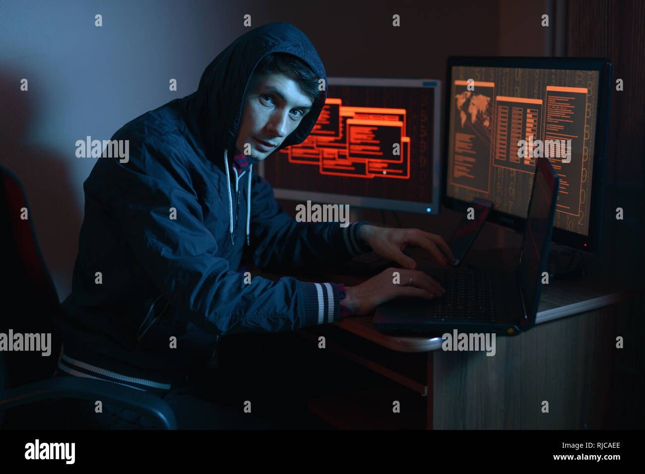 Male In The Hood Looking In The Camera Hacker Attacks And Online Fraud In The Dark On The