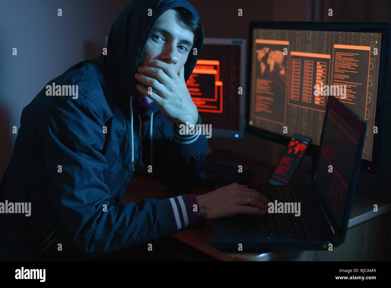 Male In The Hood Looking In The Camera Hacker Attacks And Online Fraud In The Dark On The